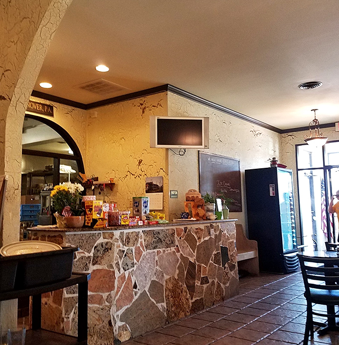 The stone counter adds rustic charm while displaying tempting treats. It's the perfect perch for solo diners or those waiting for takeout treasures.