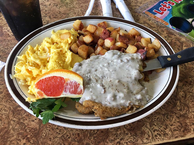 Country fried steak smothered in pepper gravy alongside golden potatoes and fluffy scrambled eggs—comfort food that hugs you from the inside out.