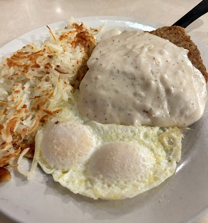 Country fried steak smothered in gravy with eggs sunny-side up. A breakfast so hearty it could fuel a tractor pull.