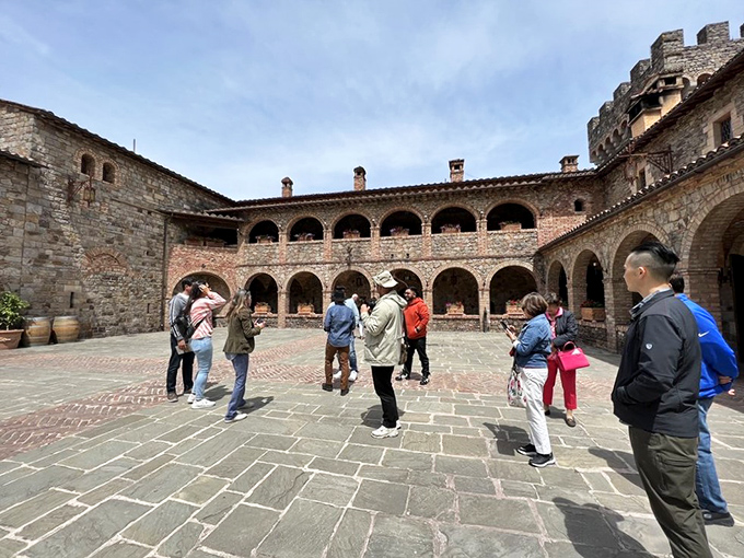 Visitors explore the castle's inner courtyard, each secretly wondering if their HOA would allow a similar renovation back home.