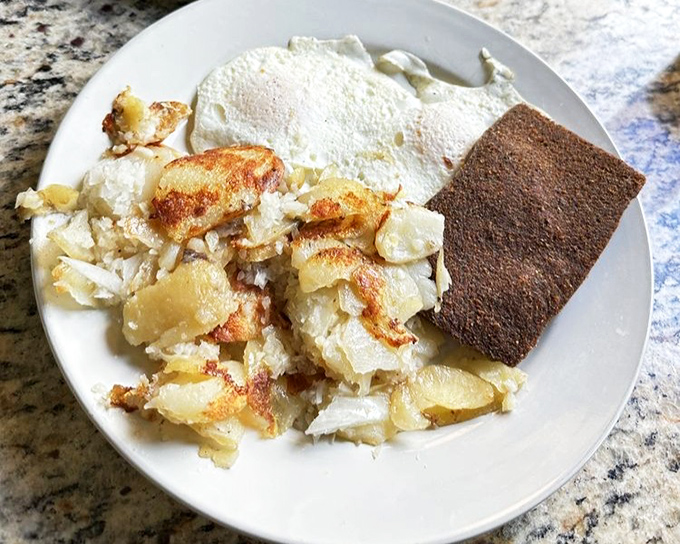 The perfect breakfast trinity: crispy home fries, eggs cooked just right, and scrapple&mdash;Pennsylvania's contribution to morning happiness.