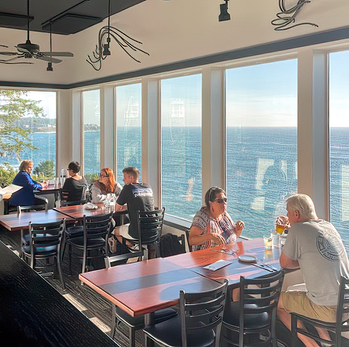 Diners bask in golden hour light while sipping, savoring, and occasionally pausing mid-bite to point at passing whales. Multitasking at its finest.