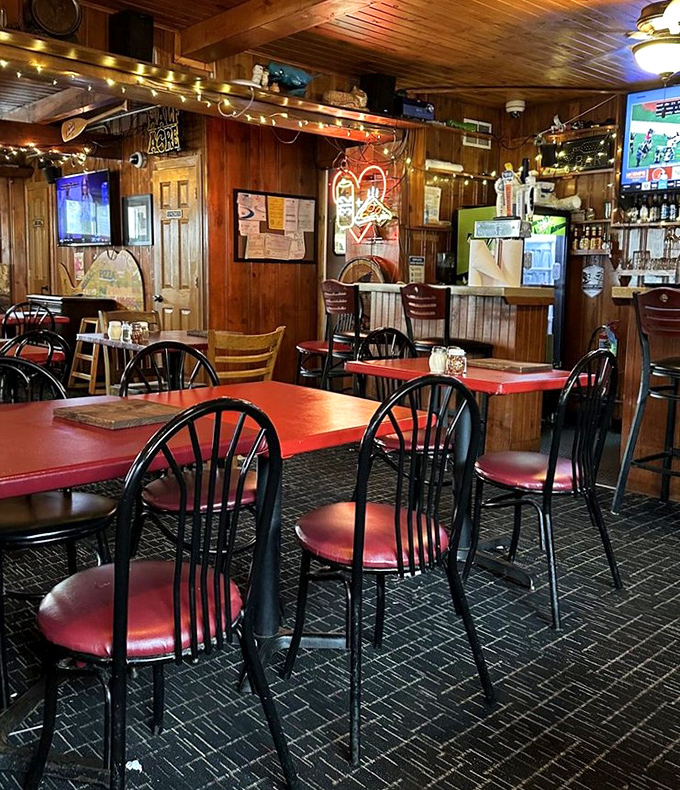 Red-topped tables surrounded by burgundy chairs create the classic pizzeria atmosphere that's become increasingly rare in chain-dominated America.