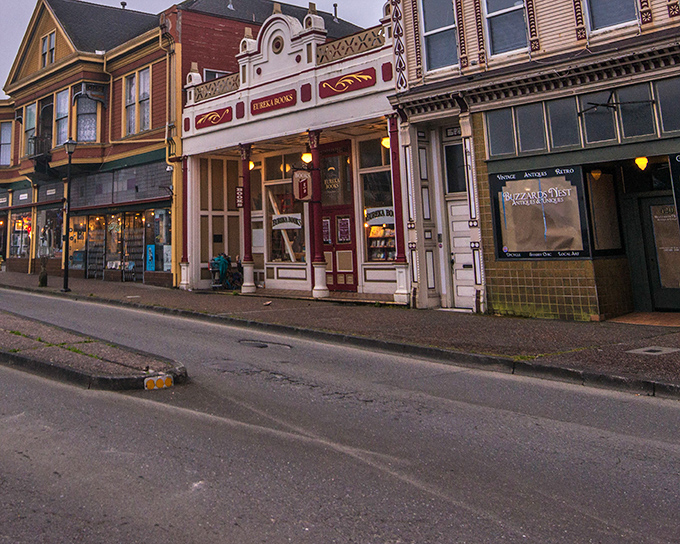 The same storefront at dusk takes on a warm, inviting glow. Evening in Eureka transforms ordinary buildings into something from a nostalgic movie set.