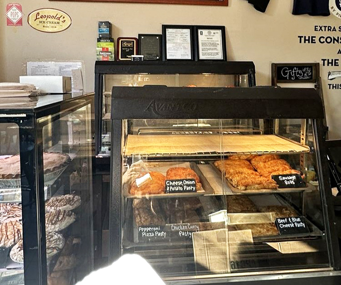 The display case showcases a United Nations of pastries where savory and sweet options peacefully coexist.