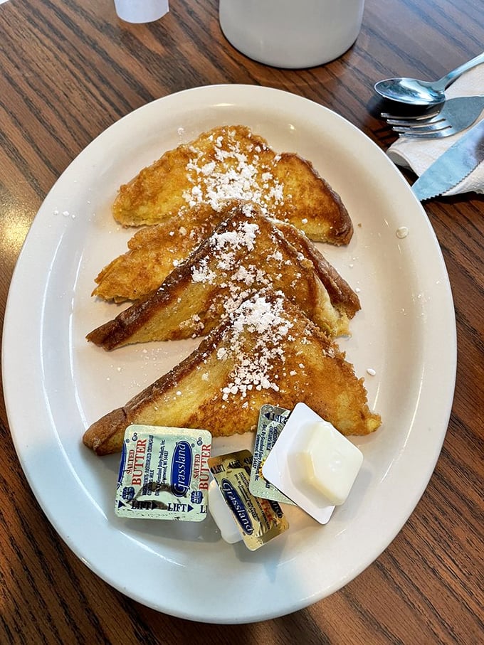 French toast dusted with powdered sugar like fresh snow on Christmas morning. Those butter packets are just waiting to create rivers of golden deliciousness.