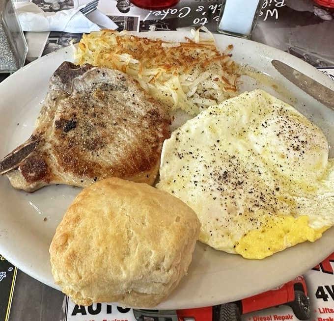 A pork chop, eggs, and a biscuit that could make a vegetarian question their life choices. This is breakfast with purpose.