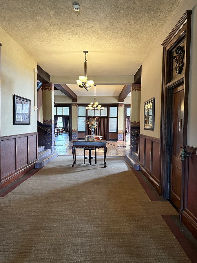 The castle's elegant hallway, with its warm wood tones and period lighting, invites exploration of what lies beyond each doorway. 