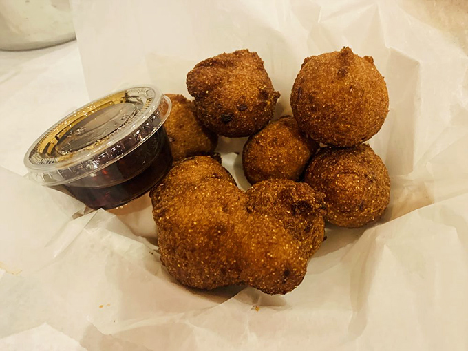 Golden hush puppies arrive like little spheres of Southern comfort, perfect for soaking up flavors.