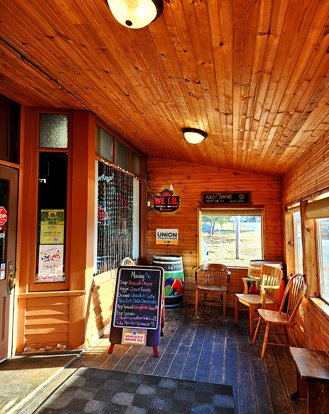 Sunlight streams through windows in the wooden porch area, where a chalkboard promises daily specials worth investigating.