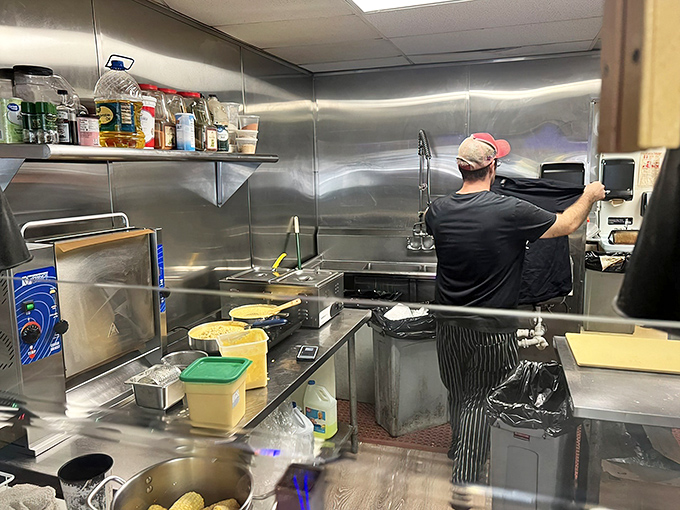 The behind-the-scenes magic. Stainless steel surfaces gleam in this working kitchen where barbecue alchemy transforms raw ingredients into smoky gold.