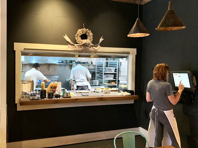 The kitchen window offers a glimpse into the choreographed chaos where coastal dreams become Midwestern reality.