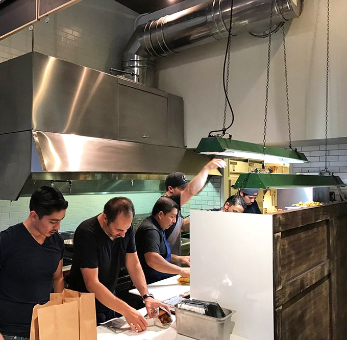 The kitchen crew in their element&mdash;culinary choreography in action. This is where the magic happens, one perfectly fried piece of chicken at a time.