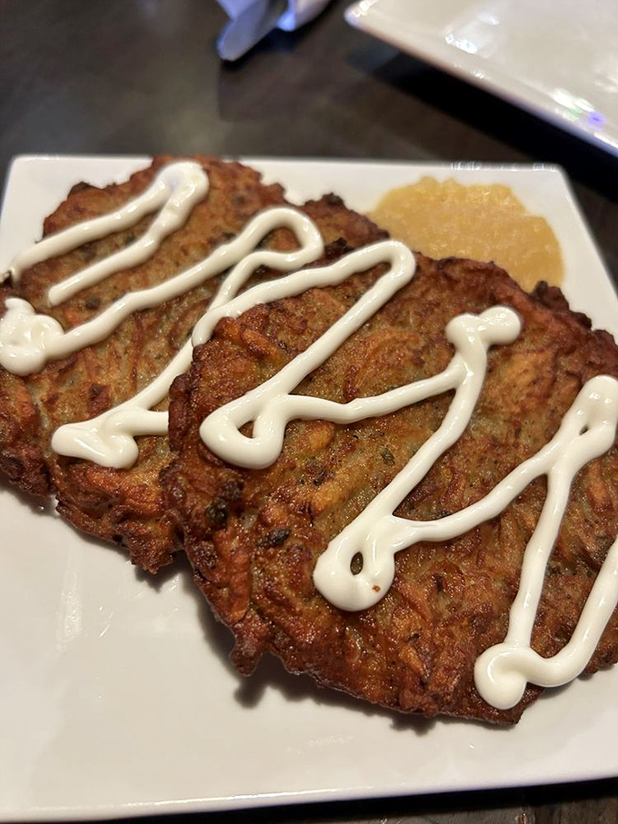Crispy potato latkes drizzled with sour cream&mdash;golden discs of happiness that crackle with each delicious bite.