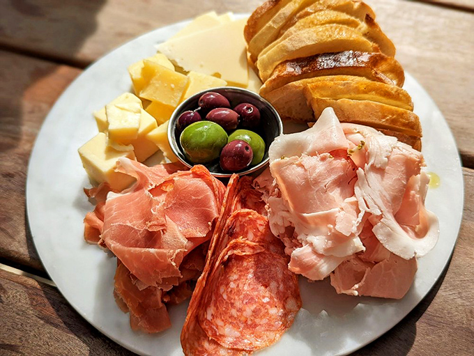 Cured meats and artisan cheeses arranged like edible artwork on a simple white canvas.