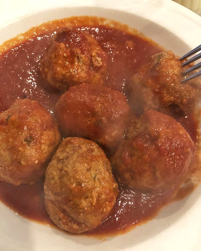 Meatballs swimming in homemade sauce – each one a perfect sphere of seasoned goodness that would make any nonna proud.