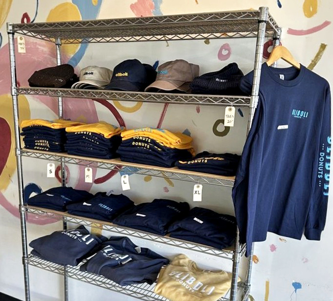 True fans take the experience home with Oliboli merch. Nothing says "I'm serious about my donuts" like branded apparel against that playful mural backdrop.