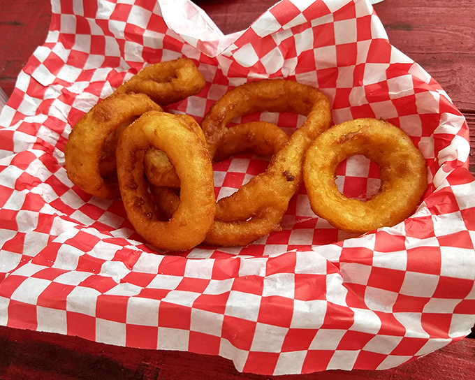 Onion rings in their ideal form—golden, crispy, and nestled in a red-checkered basket. Some traditions don't need updating, just perfecting.