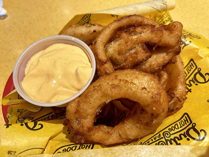 Crispy, golden onion rings with creamy sriracha sauce&mdash;because sometimes your hot dog needs a sidekick with a spicy attitude.