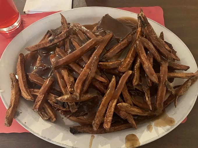 Gravy isn't just a condiment here; it's practically a beverage &ndash; these open-faced roast beef fries swim in a pool of savory goodness that demands bread for sopping. 