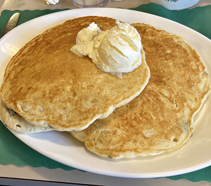 Pancakes so fluffy they could double as pillows, crowned with a melting pat of butter that's creating its own little river of goodness.