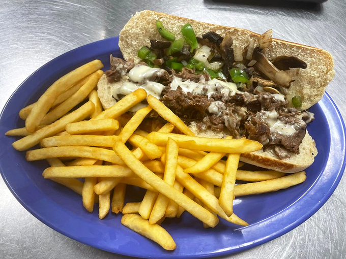 The Philly cheesesteak: Pennsylvania's gift to Florida, served with a golden army of french fries standing at attention. A sandwich that demands to be respected—and devoured.