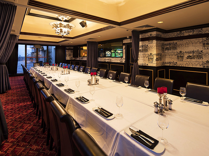 The private dining room stands ready for celebration, where important deals and special occasions find their perfect backdrop among pristine table settings.