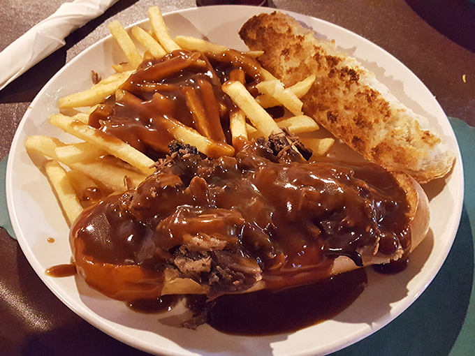 Gravy cascades over tender roast beef like Niagara Falls' delicious cousin. This isn't just a sandwich&mdash;it's a savory waterfall on a plate.