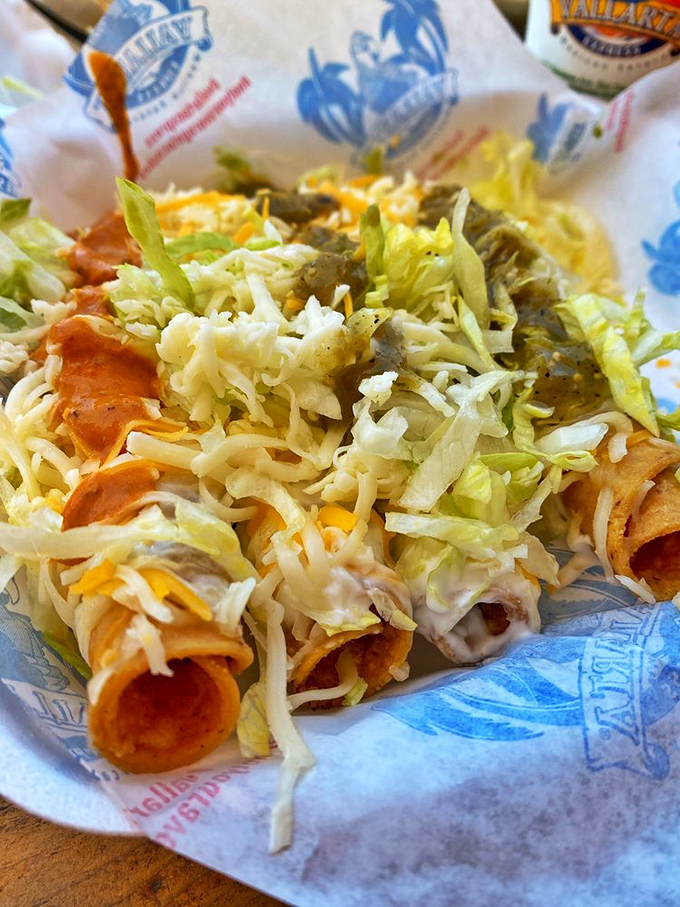 Rolled tacos lined up like crispy soldiers, topped with a confetti of lettuce, cheese, and sauce. Finger food elevated to an art form.