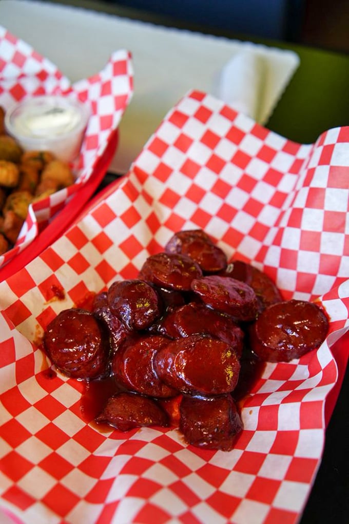 Smoked sausages glistening with sauce in their red-checkered basket. Like meaty rubies waiting to be discovered.