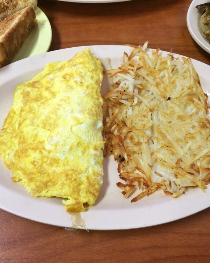 This sausage omelet looks like a golden envelope stuffed with savory surprises waiting to be discovered inside.