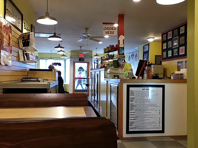 The menu boards command attention like movie posters, promising taste adventures that will have you planning return visits before you've finished your first dog.