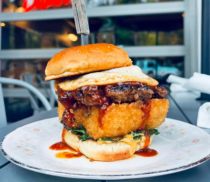 This towering burger creation defies gravity and conventional sandwich logic. The runny sauce and crispy elements create a beautiful mess worth every napkin.