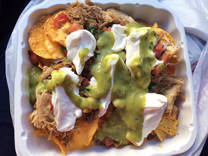 Loaded nachos crowned with shredded chicken, multiple sauces, and fresh toppings create an Instagram-worthy mountain of flavor. 