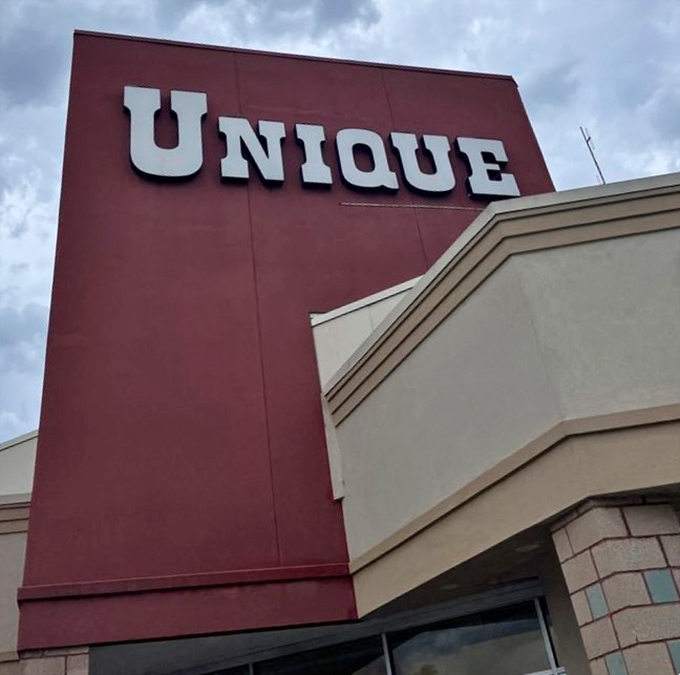 The distinctive Unique sign stands tall against cloudy skies, a landmark for thrift enthusiasts throughout Northern Virginia.
