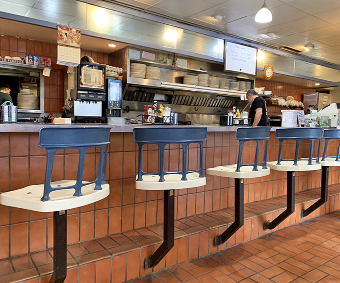 Those blue counter stools have supported generations of breakfast enthusiasts, waiting patiently for their next loyal patron.