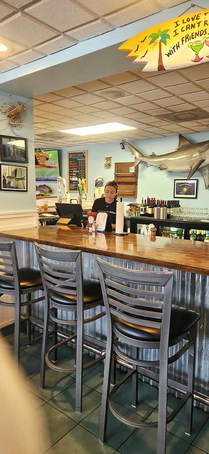 The bar area isn't trying to be trendy. That surfboard sign saying "I love to drink with friends" speaks the universal truth of good seafood joints.