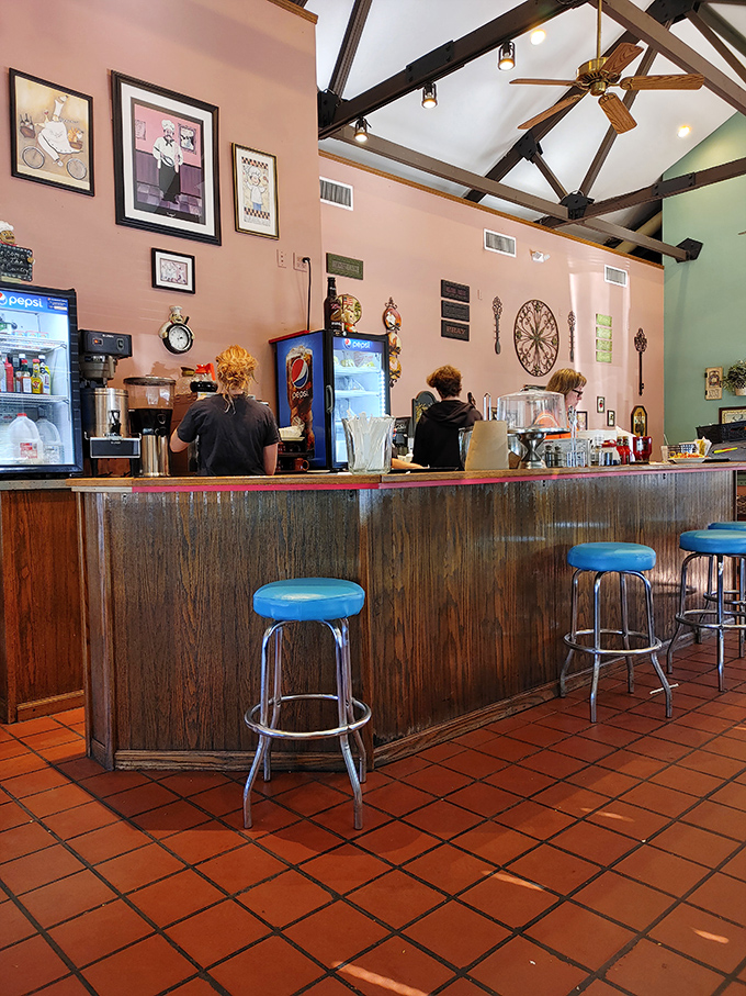 Behind this wooden counter, breakfast magic happens. The blue stools invite you to sit a spell and watch the choreography of short-order cooking.