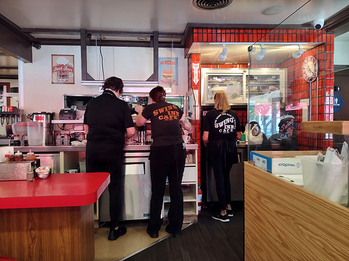 The kitchen crew works their magic behind the scenes, their matching shirts a testament to the teamwork required to maintain barbecue excellence day after day.