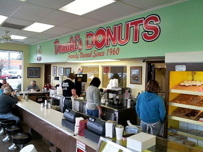 Morning rituals unfold at the counter, where regulars and staff perform the daily dance of donuts and coffee with practiced precision.