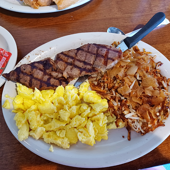 The holy trinity of breakfast—golden eggs, perfectly grilled steak, and hash browns crisped to perfection—a plate that says "today is going to be extraordinary."