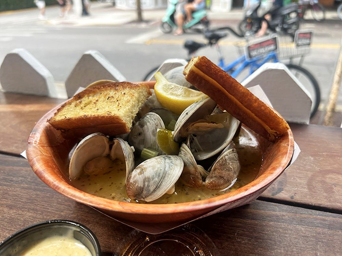 Steamed clams bathing in buttery broth—the kind of dish that requires both bread and a moment of respectful silence.