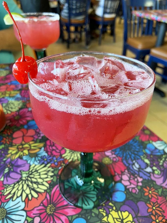 A strawberry margarita so vibrantly red it's practically winking at you. The cherry garnish isn't decoration&mdash;it's a promise of good times ahead.