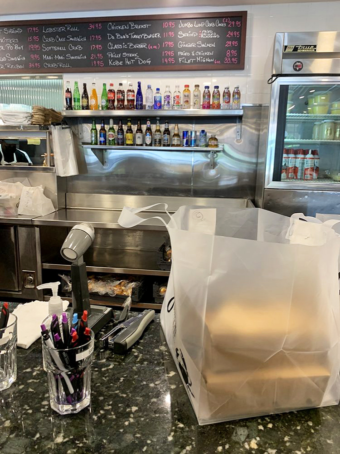 Behind the counter, efficiency meets anticipation as takeout orders are prepared for those who prefer their seafood feast at home.