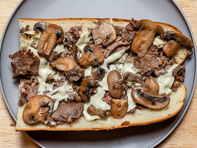 The mushroom cheesesteak: umami heaven on a roll. Those saut&eacute;ed mushrooms and melted cheese create a flavor combination worth crossing state lines for.