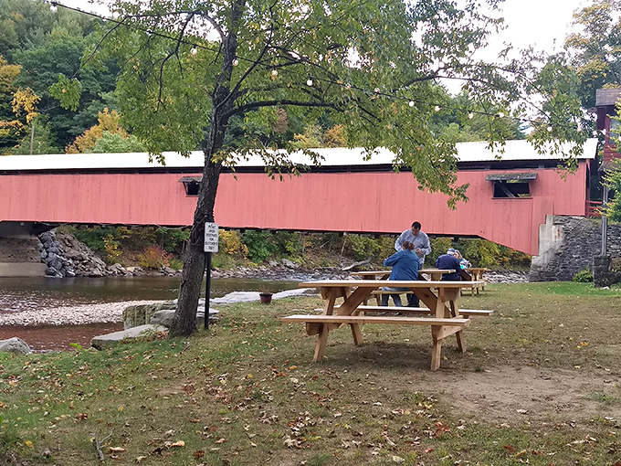 Picnickers enjoy lunch with a side of living history. The bridge has been photobombing family memories since before cameras existed.