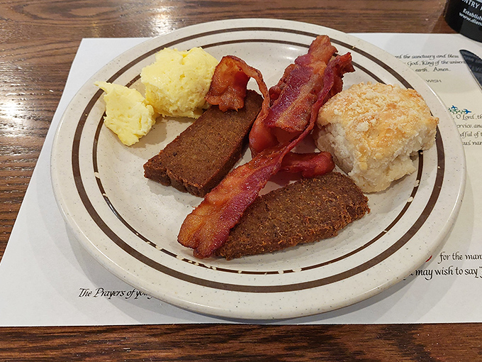 Perfectly cooked bacon and sausage alongside fluffy scrambled eggs represent breakfast done absolutely right every time.