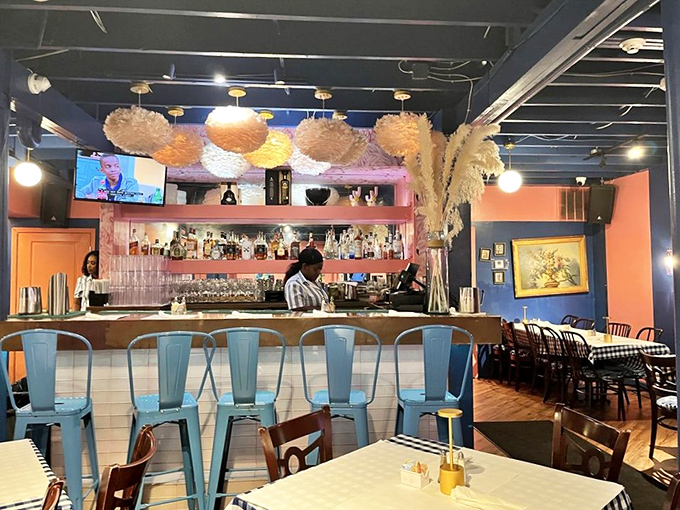 The bar area promises liquid brunch happiness with its warm wood tones and impressive array of bottles standing at attention.