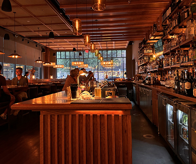 The bar where liquid magic happens. Those copper accents and warm lighting make even waiting for your table a pleasure.