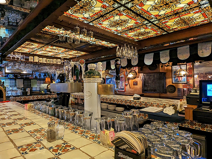 The bar at Old Heidelberg is a stained-glass wonderland. Beer steins stand at attention, ready to deliver liquid happiness to thirsty patrons.